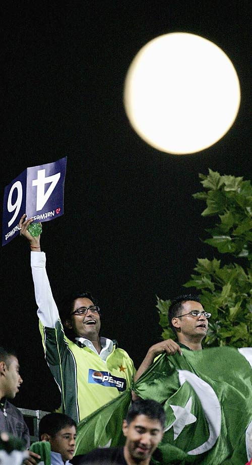 Pakistani fans roar their support under a nearly full moon ...