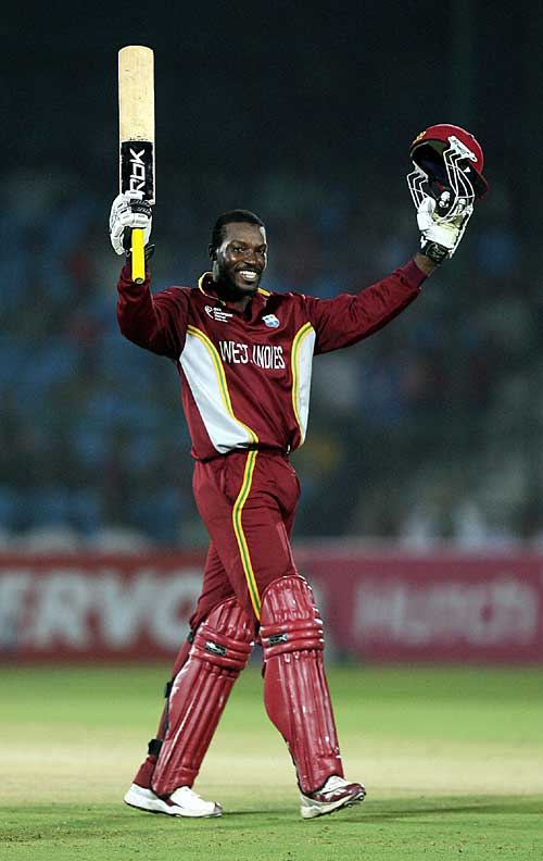 Chris Gayle raises his arms after reaching his ton against Bangladesh ...