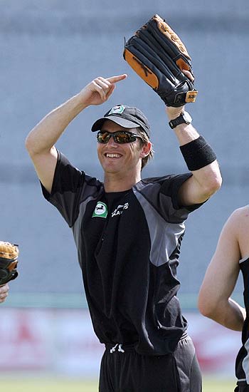 Shane Bond pouches one without a fuss during a fielding session ...