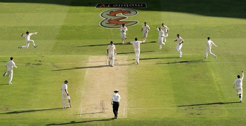The Australian team converge to celebrate the wicket of Alastair Cook ...