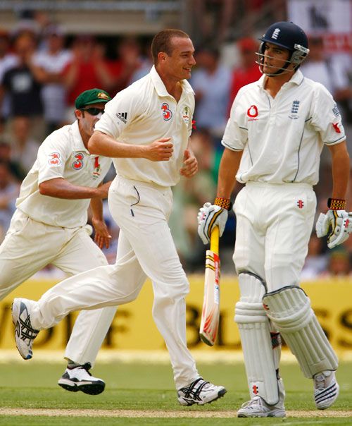 Stuart Clark celebrates as a disappointed Alastair Cook heads towards ...