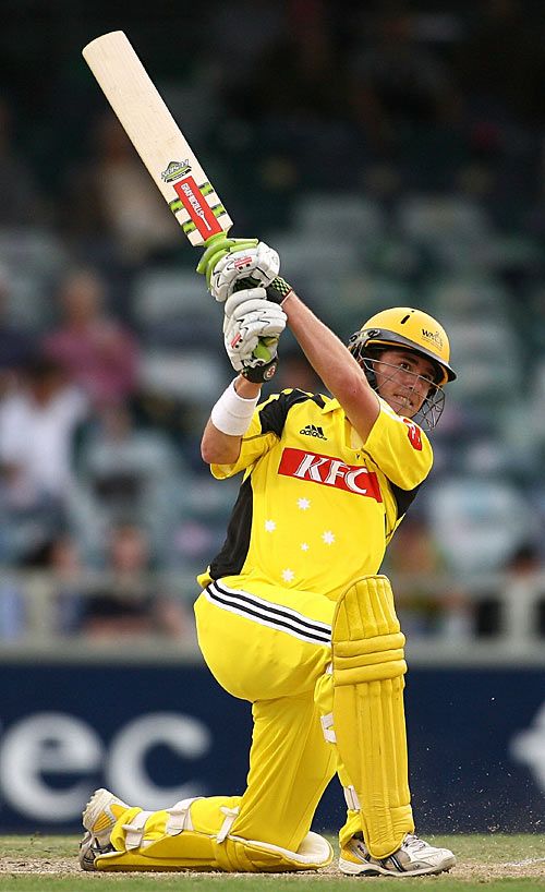 Down on one knee, Marcus North launches a boundary over the top ...