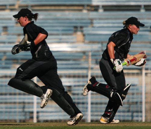 Maria Fahey (left) and Helen Watson of New Zealand cross over for a ...