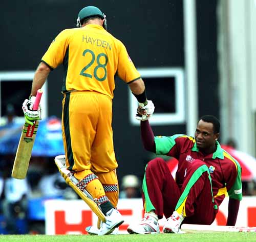 Matthew Hayden helps Marlon Samuels up after the bowler dived trying to ...