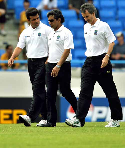 Umpires Aleem Dar, Asad Rauf and Billy Bowden walk down to inspect the ...