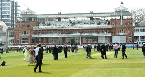 Spectators bask and stroll in the sunshine at the lunch break ...