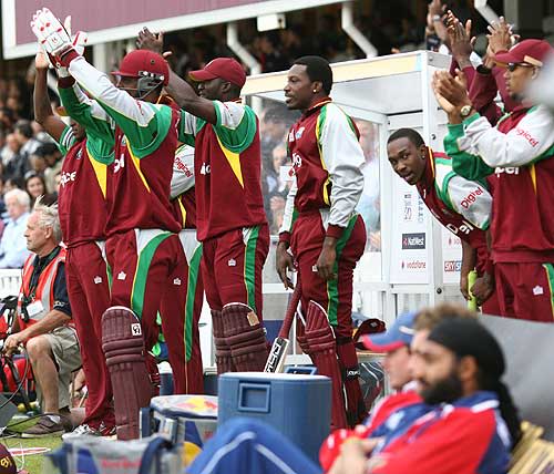 The West Indian dug-out applauds the efforts of their batsmen ...