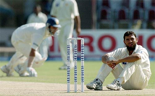 Saqlain Mushtaq watches a ball going for a boundary off his bowling ...