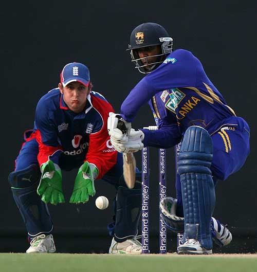 Chamara Silva plays through the off side as Phil Mustard looks on ...