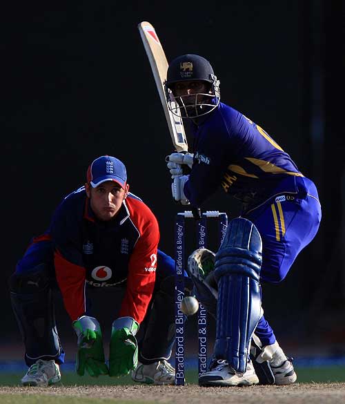 Chamara Silva gets into position to drive, as Phil Mustard looks on ...