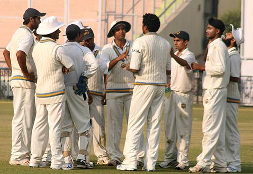 The Punjab team huddles up after the fall of Suresh Raina ...