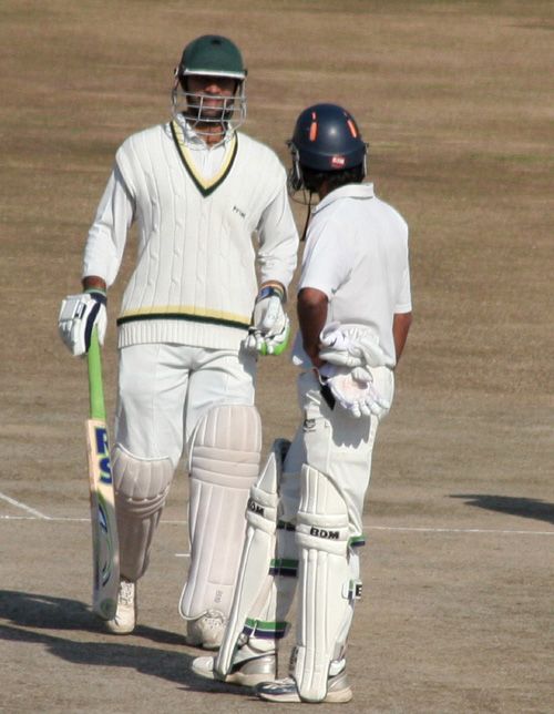 Mukesh Sharma talks to his team-mate after completing his century ...
