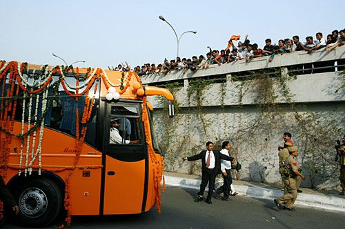 Fans on the streets cheer as the Indian team bus passes by ...
