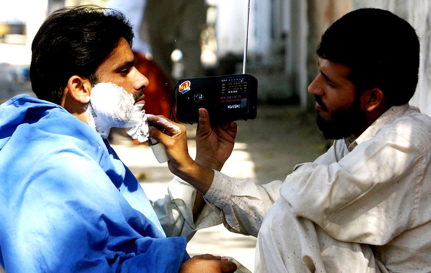A Pakistani fan listens to the radio commentary of the India-Pakistan ...