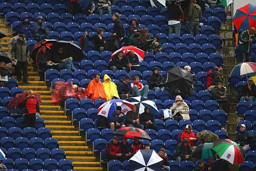 The hardy spectators try to shelter against the rain | ESPNcricinfo.com