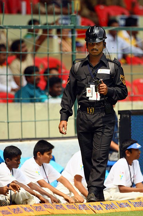 A security official walks around the ground with a bomb detector ...
