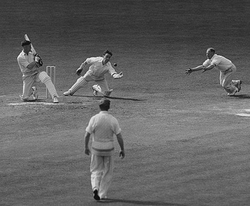 Keeper Harold Stephenson and fielder John Lawrence try to catch a ball ...