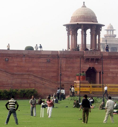 Indian government workers play a game of cricket during their lunch ...
