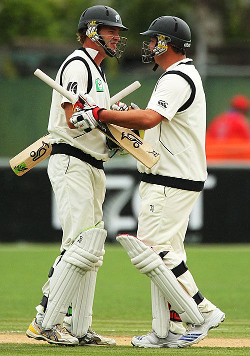 Tim McIntosh is congratulated by Jesse Ryder on reaching his maiden ...