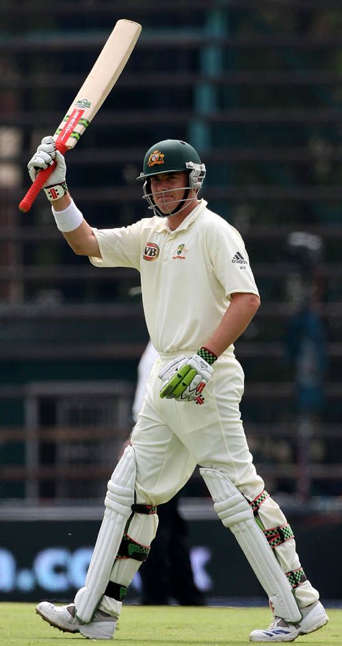 Marcus North raises his bat after reaching his half-century ...
