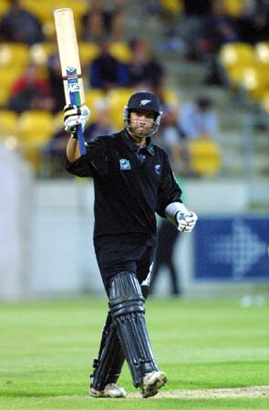 McMillan raises his bat to the crowd to celebrate his half century ...