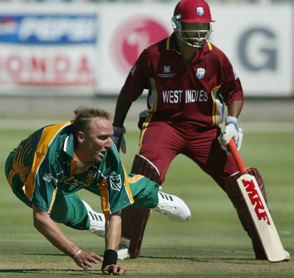 Allan Donald makes a diving stop off his own bowling, as Brian Lara watches keenly ...