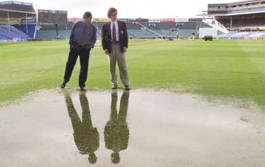 Umpires Venkataraghavan and Brent Bowden inspect a large puddle on the ...