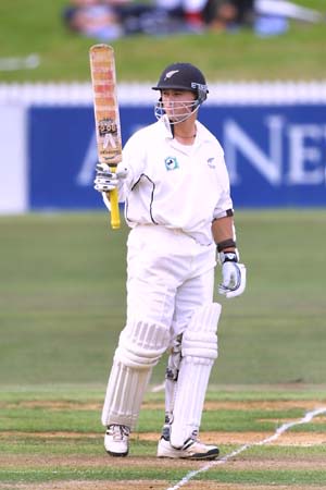 Bell raises his bat to celebrate his third Test half century ...