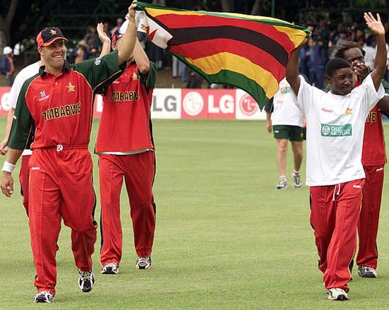 Heath Streak and wicket-keeper Tatenda Taibu carry the national flag ...