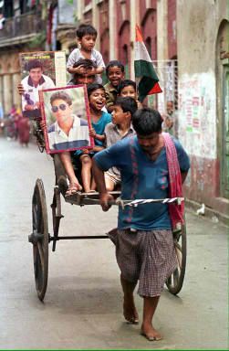 A rickshaw puller in Calcutta tows a load of children celebrating the ...