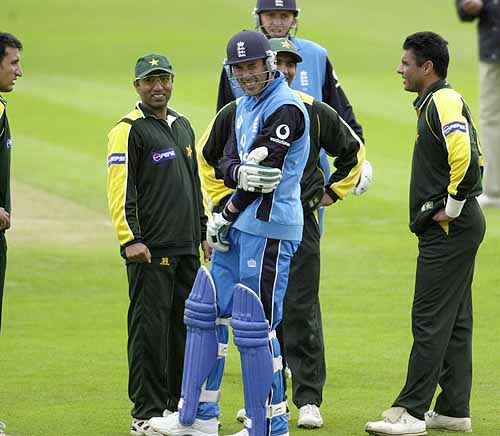 Hollioake has been struck by a fielders return and needs the attention ...