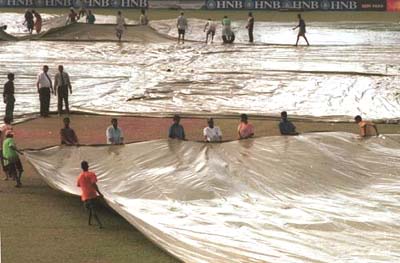 Ground staff collect water from the pitch area | ESPNcricinfo.com