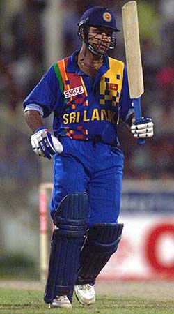 Atapattu raises his willow to acknowledge the crowd on reaching his ...