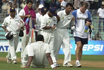 A limping Dravid is helped off the field after his fourth consecutive ...