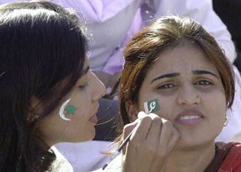 A Pakistani fan gets her face painted with the national colours ...