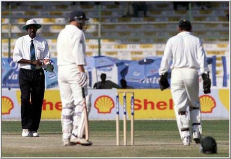 Umpire Steve Bucknor points to his watch and warns Moin about time ...
