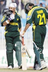 Pakistani batsman Imran Farhat (L) kisses his helmet as his mate Yasir ...