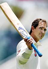 Justin Langer holds his bat aloft | ESPNcricinfo.com